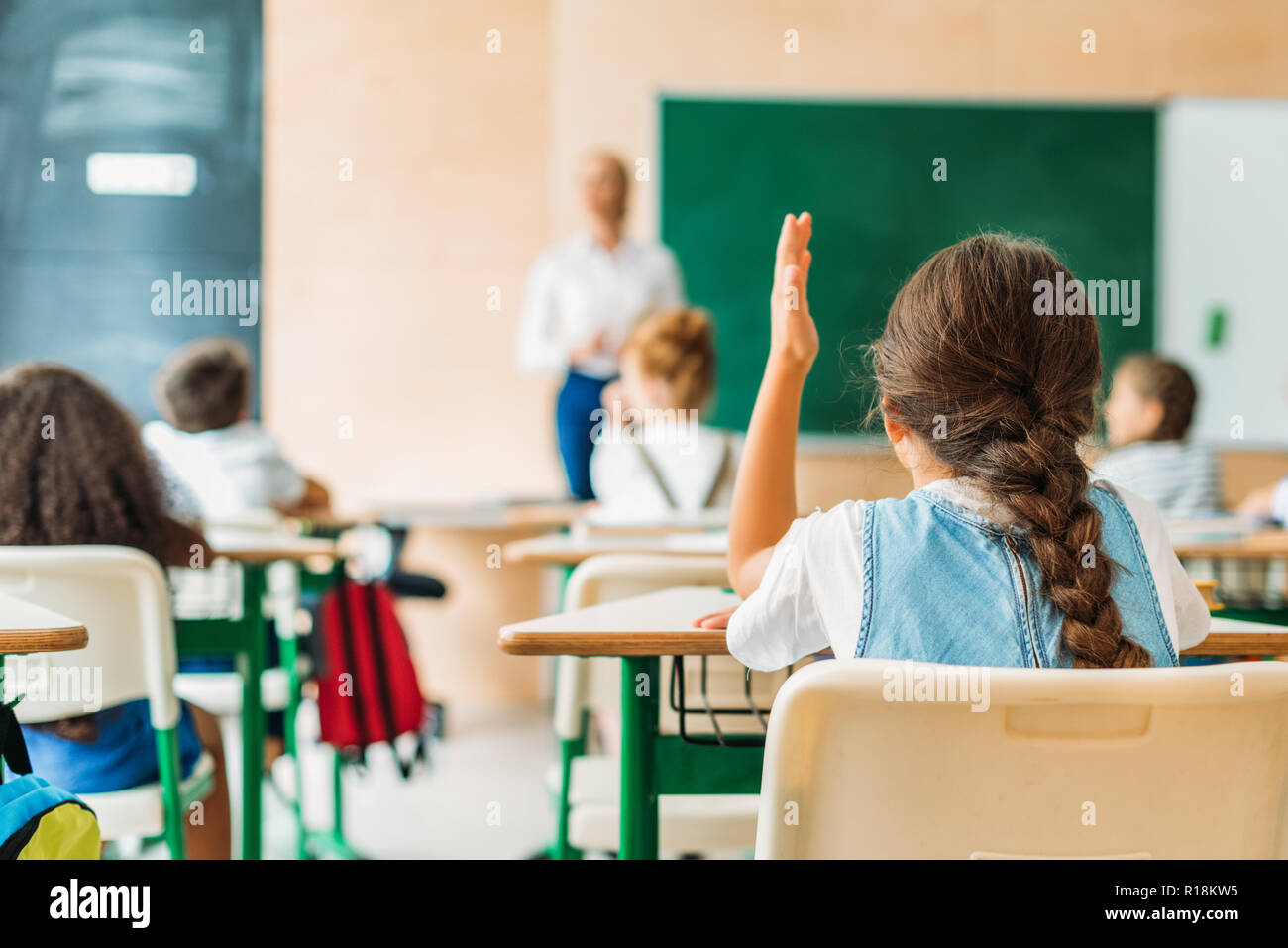 Back view schoolgirl raising hand hi-res stock photography and images ...