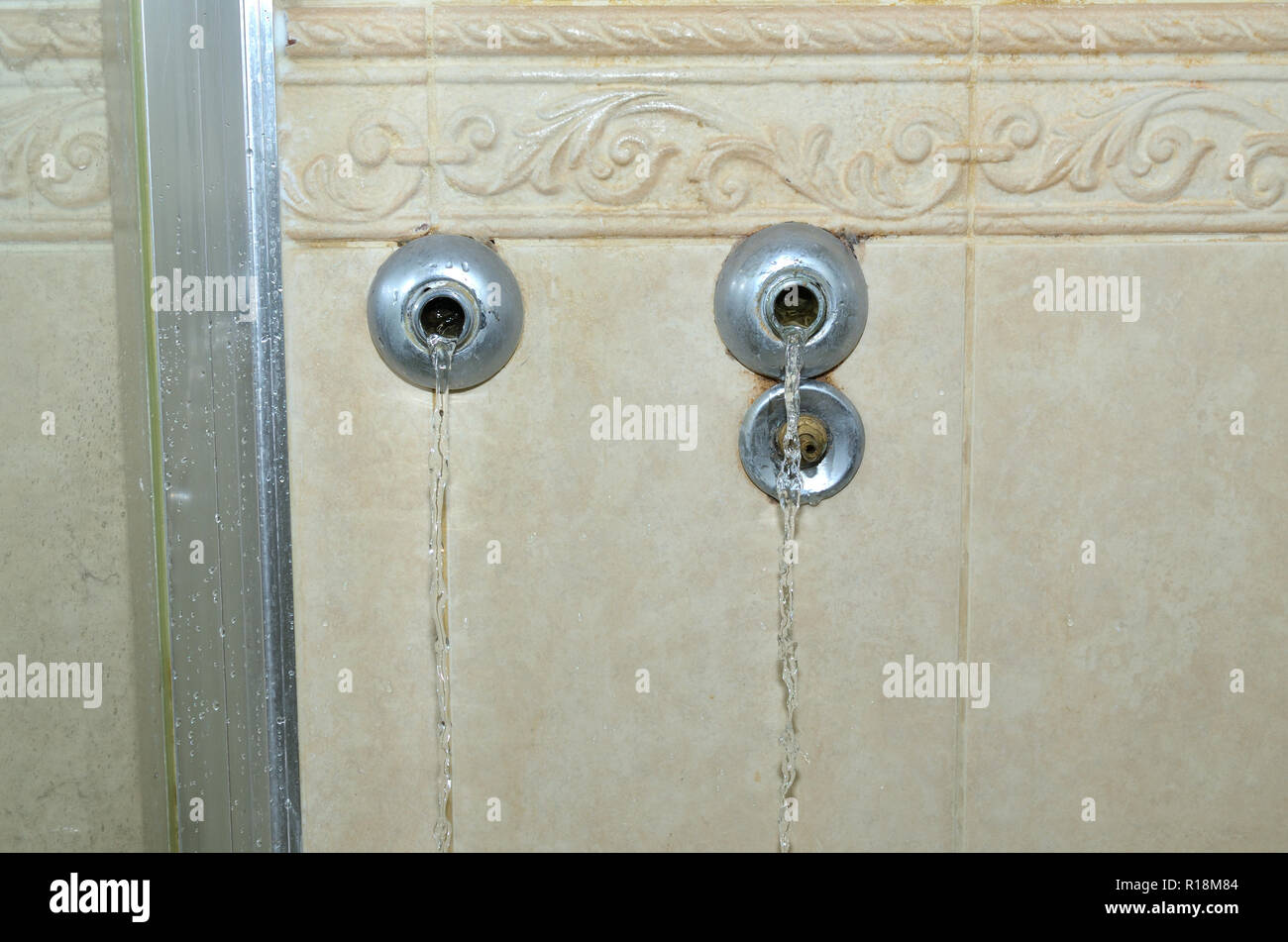 Water flowing out from pipelines on a bathroom wall Stock Photo - Alamy