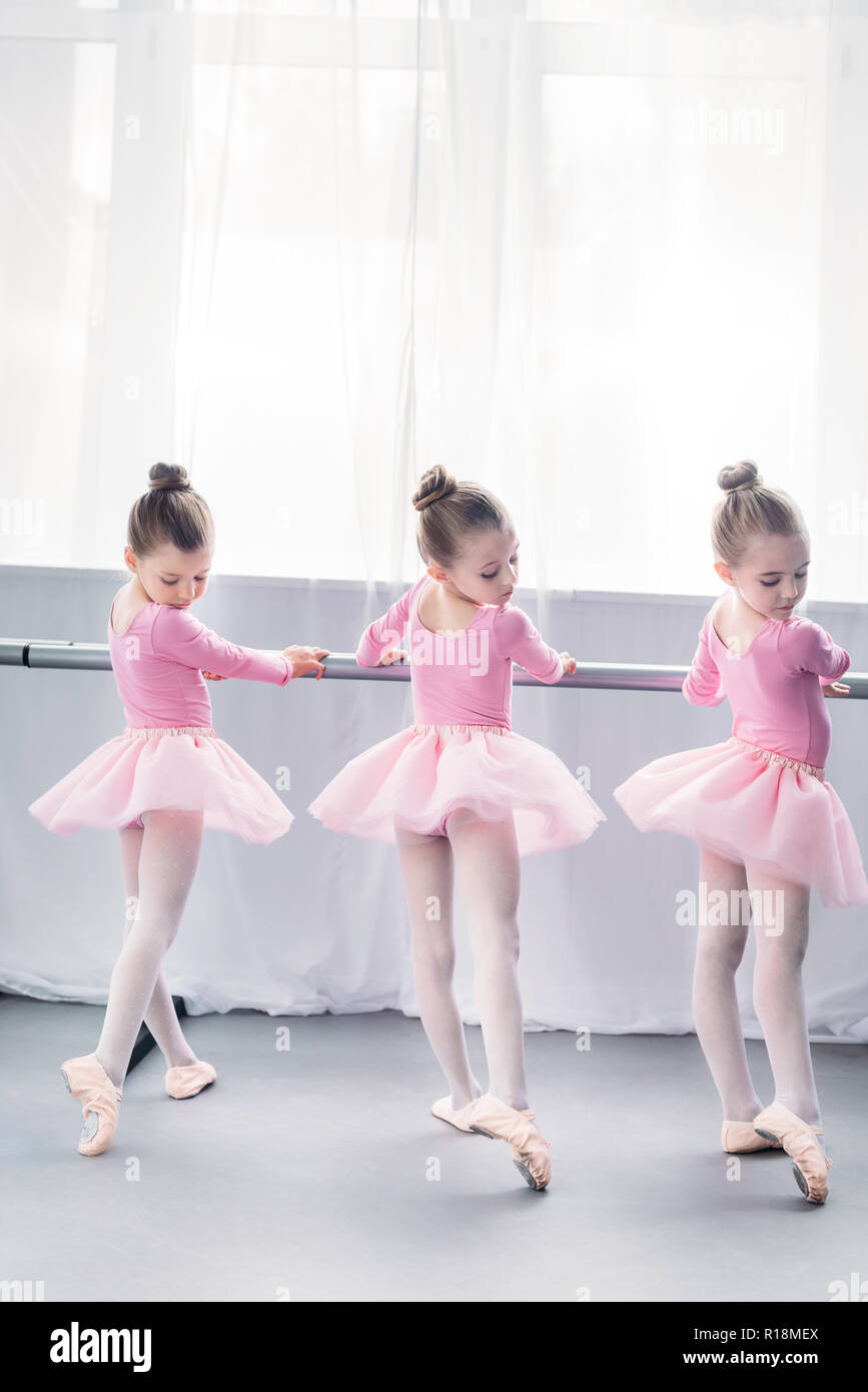 back view of graceful little ballerinas practicing ballet in studio ...