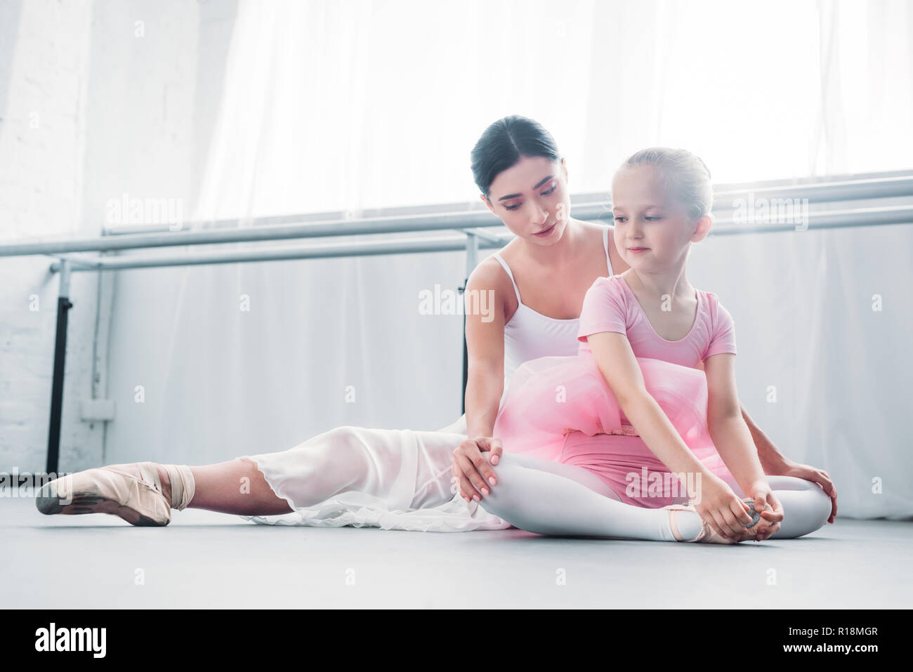 young ballet teacher training with cute little child in ballet school ...