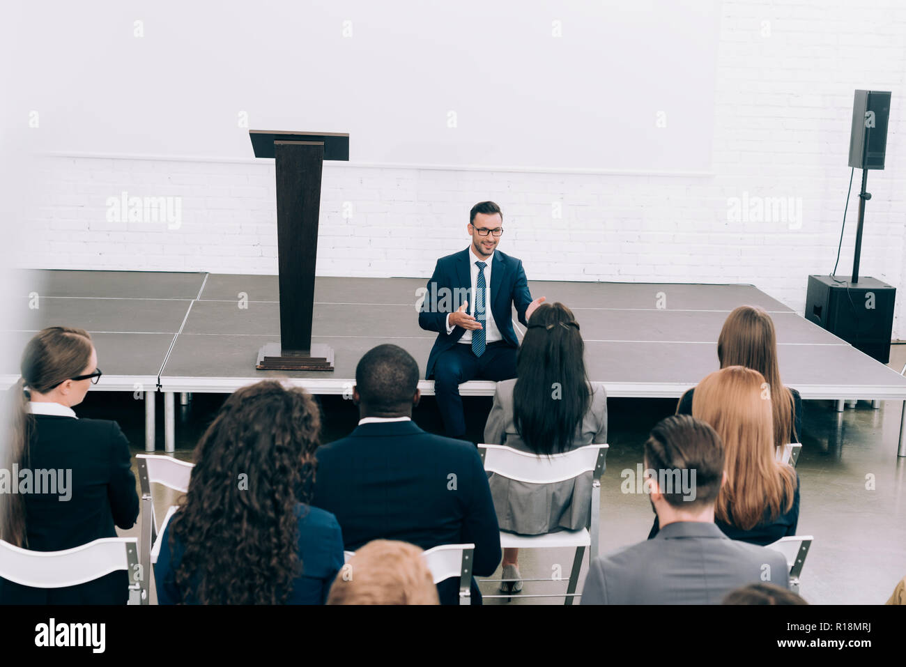 high angle view speaker sitting on stage during seminar in conference ...