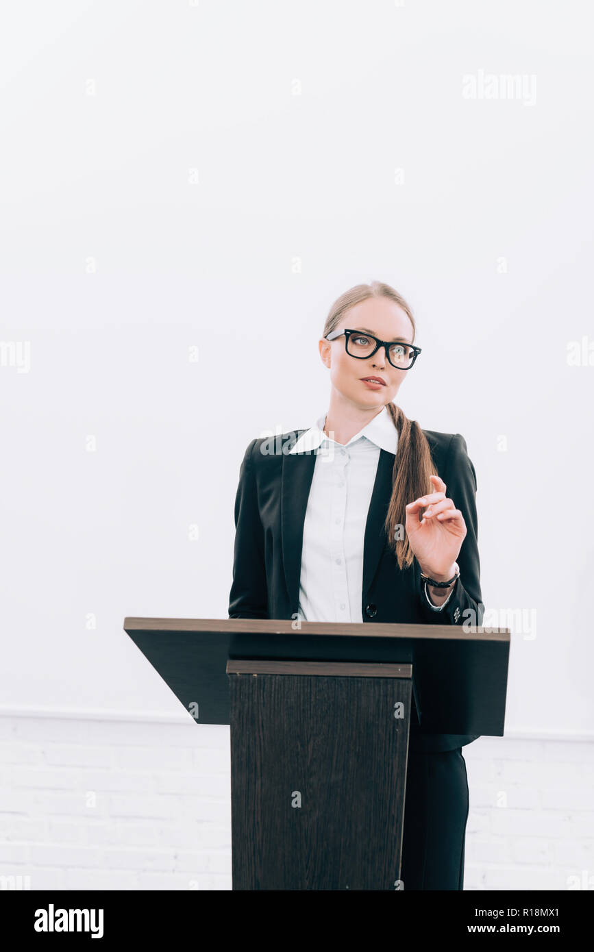 beautiful lecturer standing at podium tribune and gesturing during ...