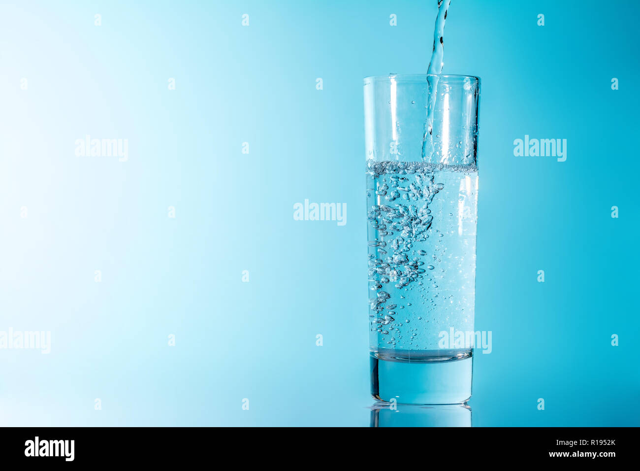 Glass of clean drinking blue water with bubbles Stock Photo - Alamy