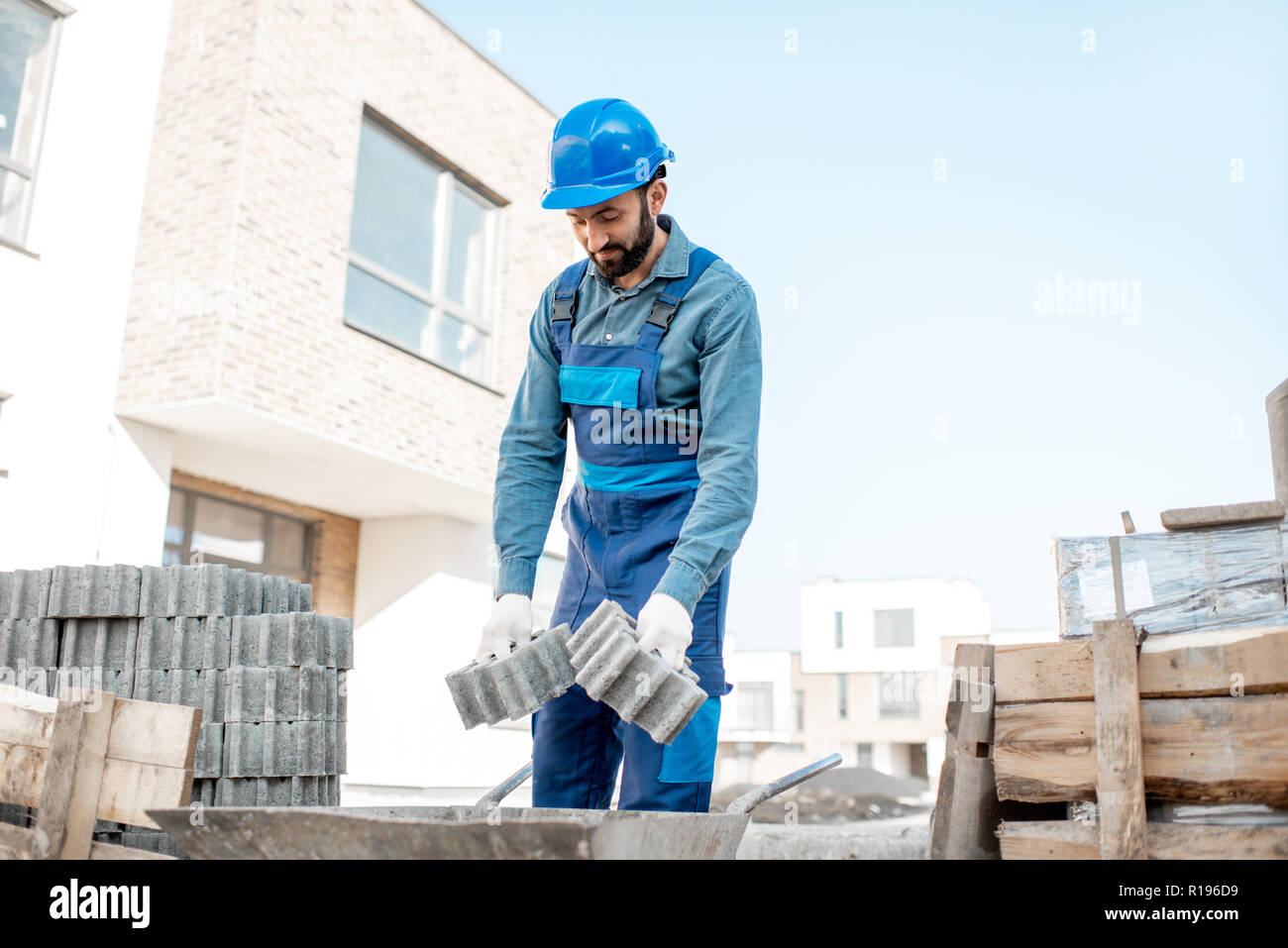 Builder loading paving tiles into the pushcart standing on the ...