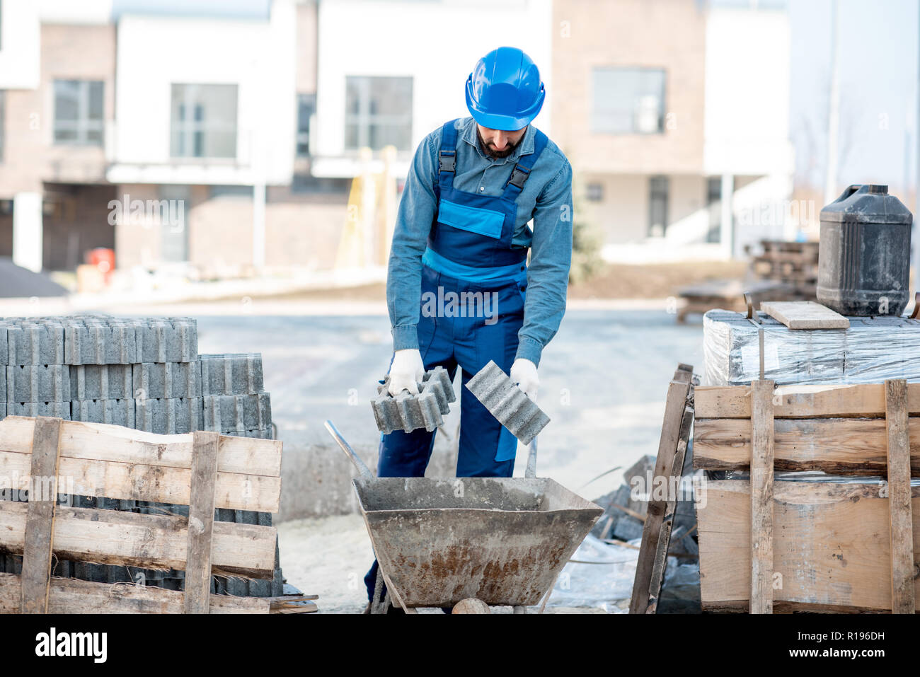 Builder loading paving tiles into the pushcart standing on the ...