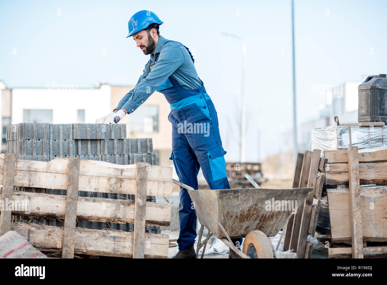 Builder loading paving tiles into the pushcart standing on the ...