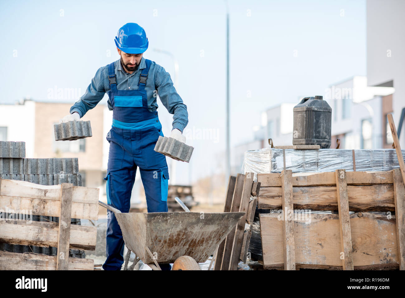 Builder loading paving tiles into the pushcart standing on the ...