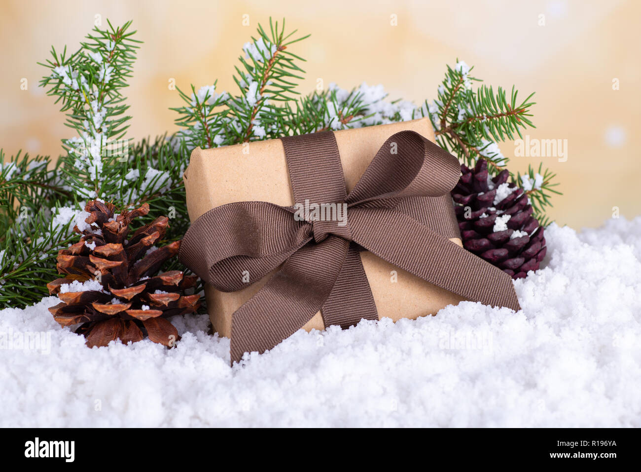 Christmas present wrapped in brown paper and ribbon with pine cones and ...