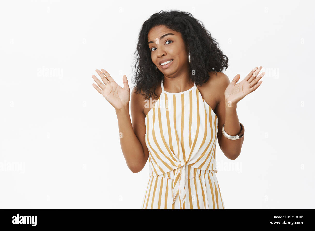 Studio shot of awkward displeased funny dark-skinned woman raising ...