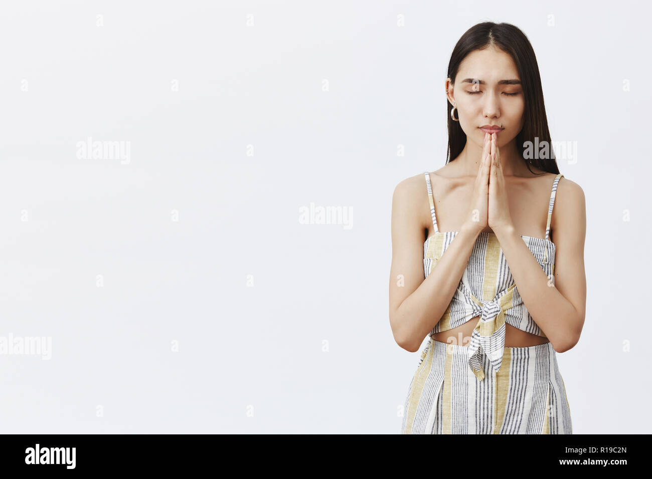 Woman praying before dinner, thanking for food. Portrait of relaxed and ...