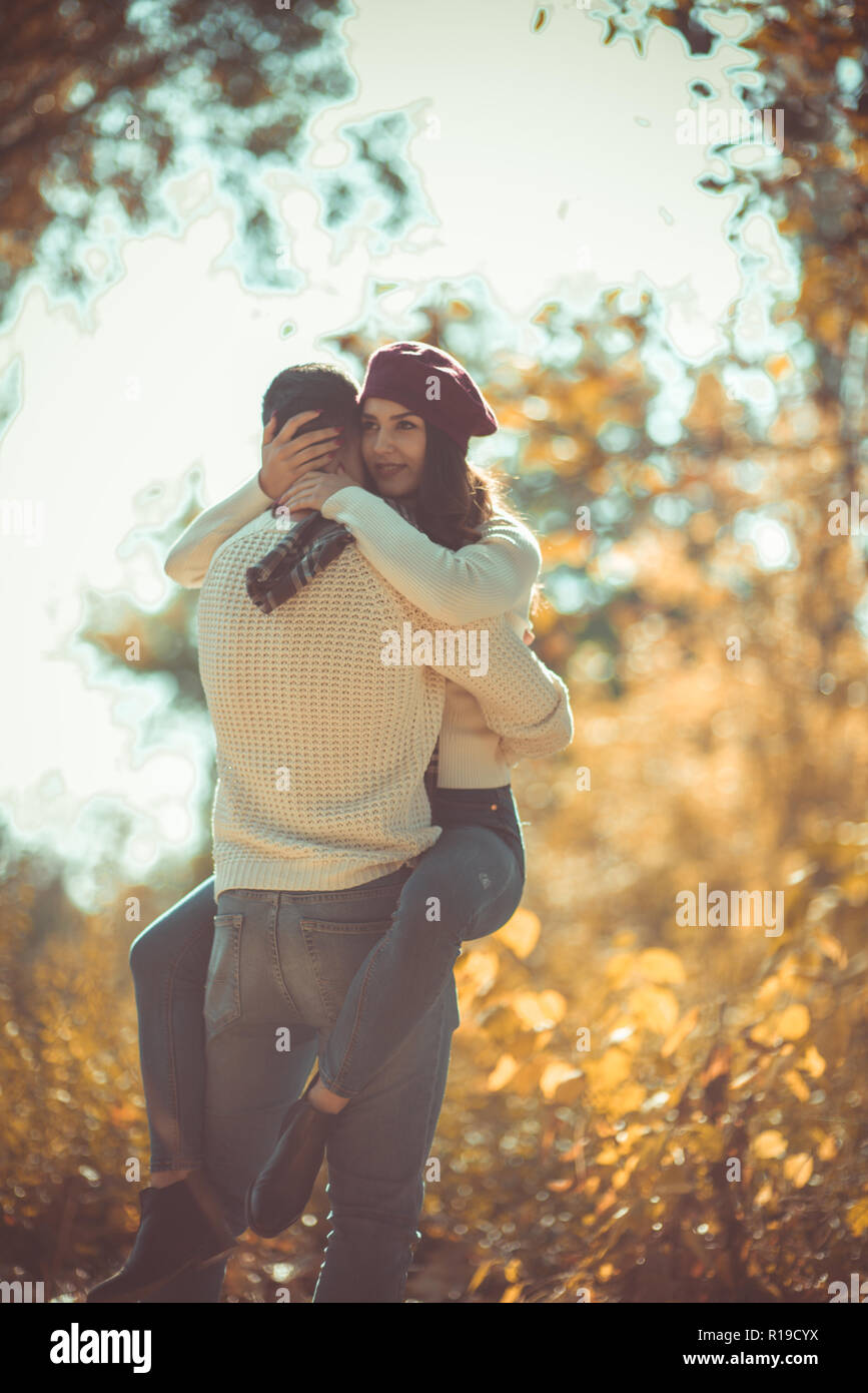 Modern young couple is spending time in nature, hugging and cuddling ...