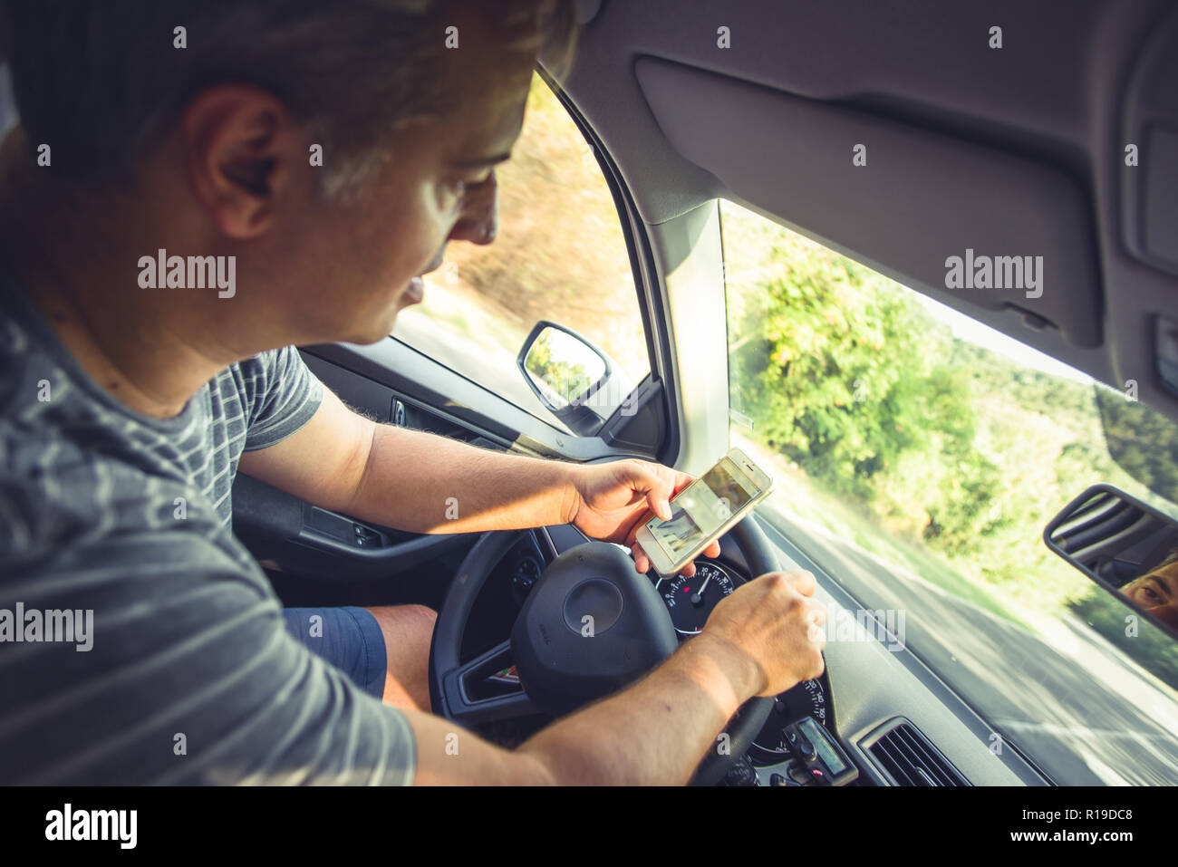 Man texting on mobile phone during recklessly driving a car Stock Photo ...