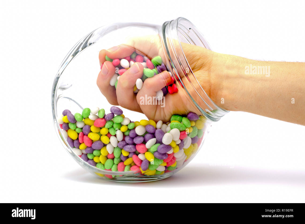hand in a jar with colored candies on a white background Stock Photo ...