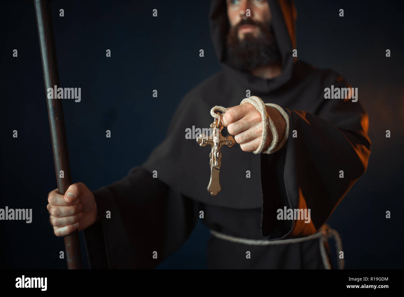 Medieval monk with wooden stick and cross in hands, religion ...