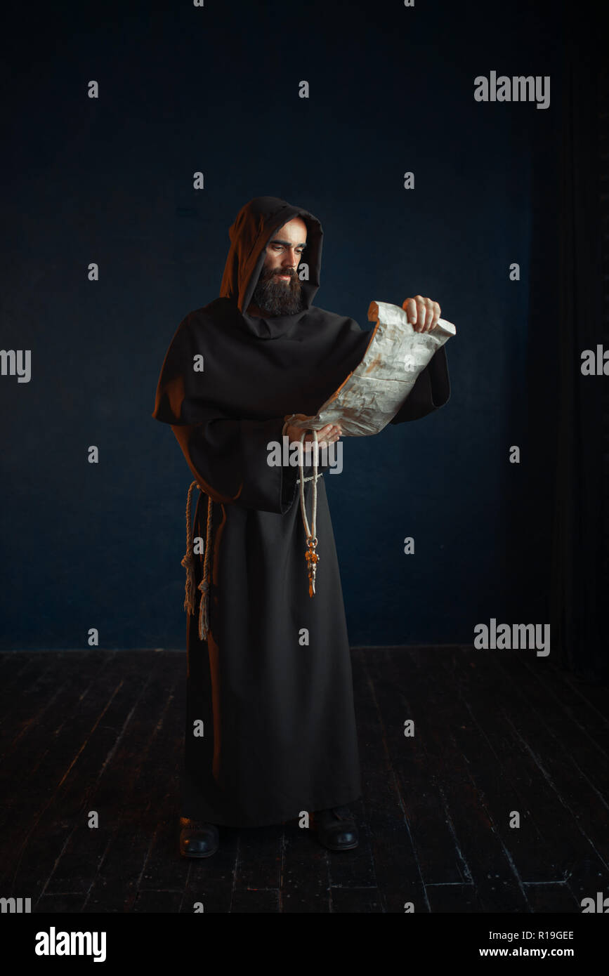 Medieval monk reads a prayer in the ancient manuscript, religion ...