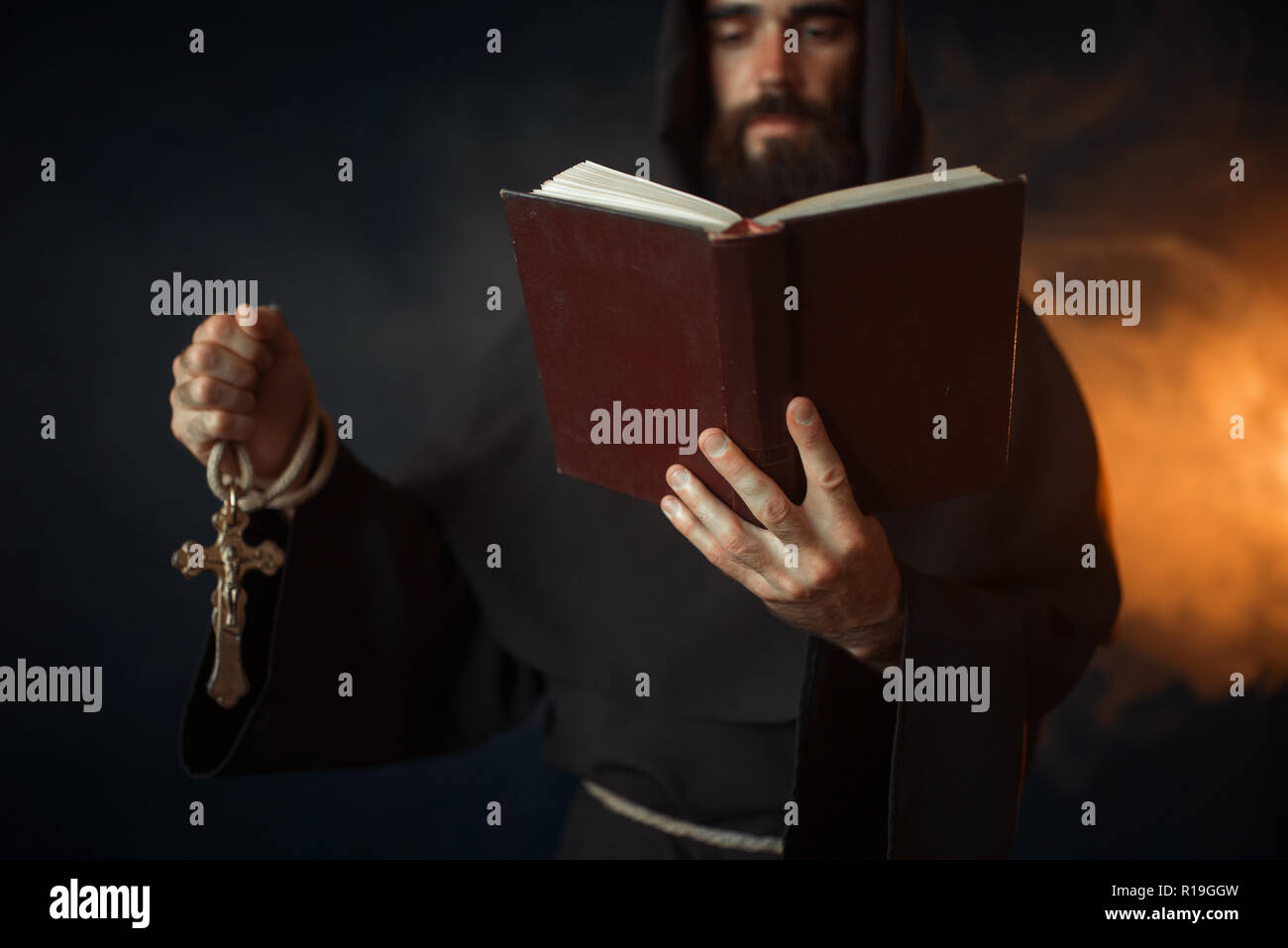 Medieval monk praying with book in hands in church, secret ritual ...