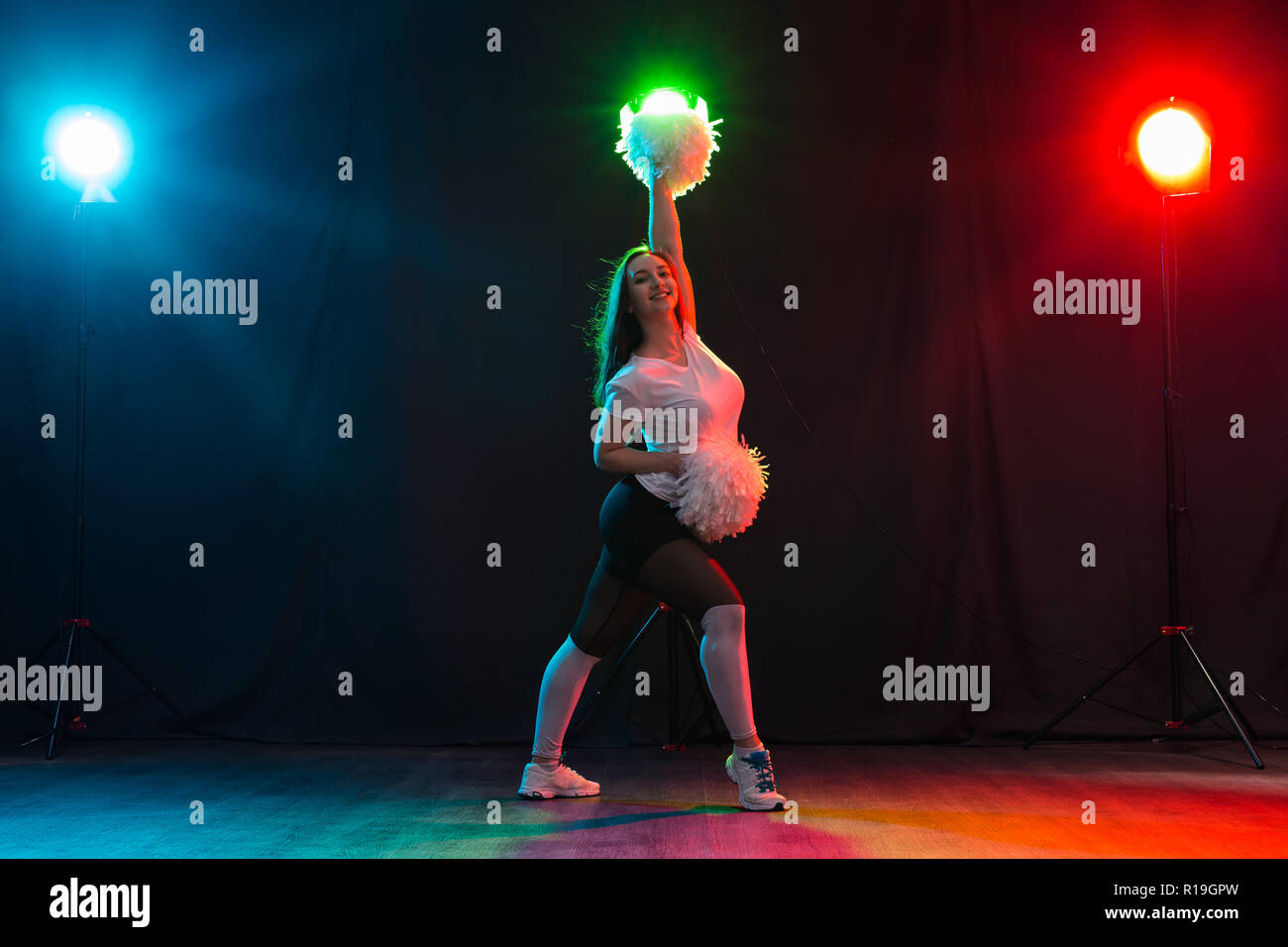 Full length portrait of cheerleader dancing with pom-poms Stock Photo ...