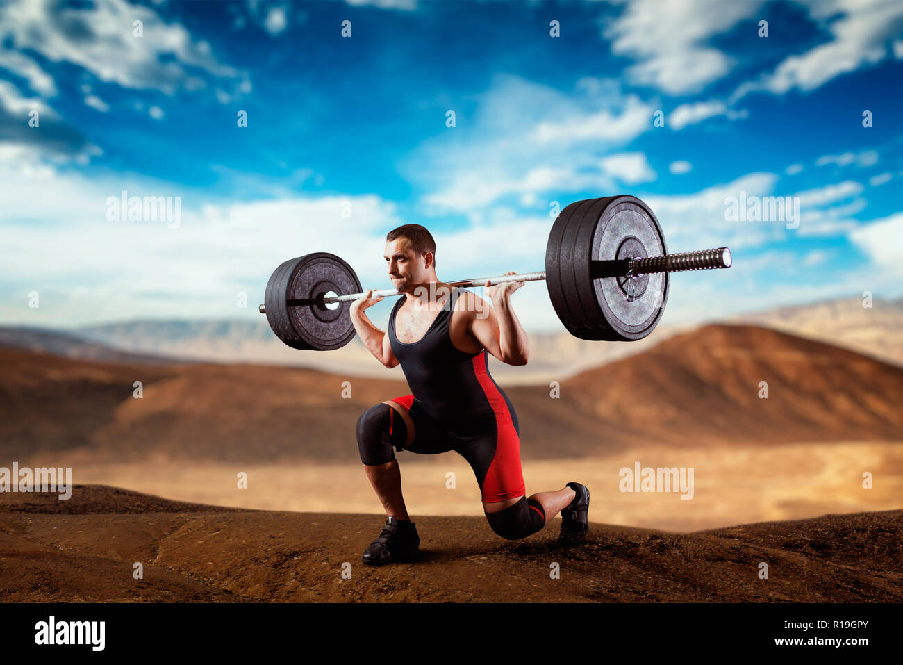 Muscular weightlifter doing squats with a barbell, deadlift, sandy ...