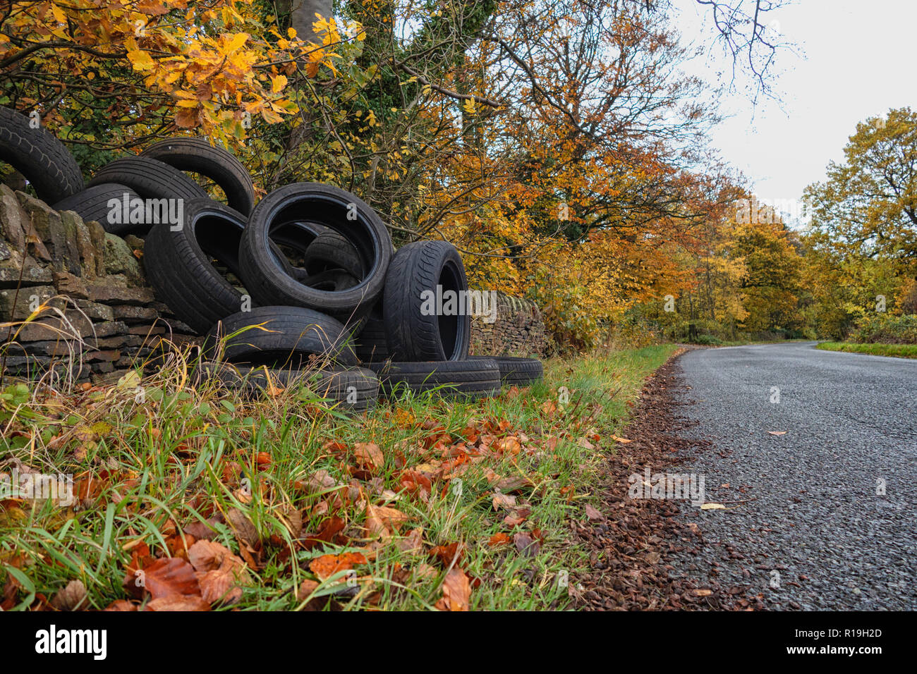 A pile of used car tyres dumped on side of a pretty country lane in ...