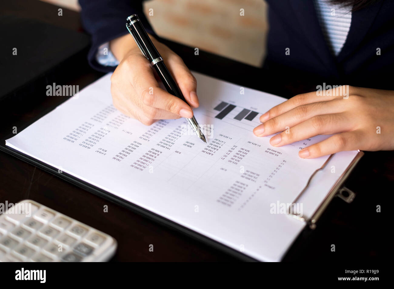 Businesswomen are pointing numbers, graph, chart in business results ...