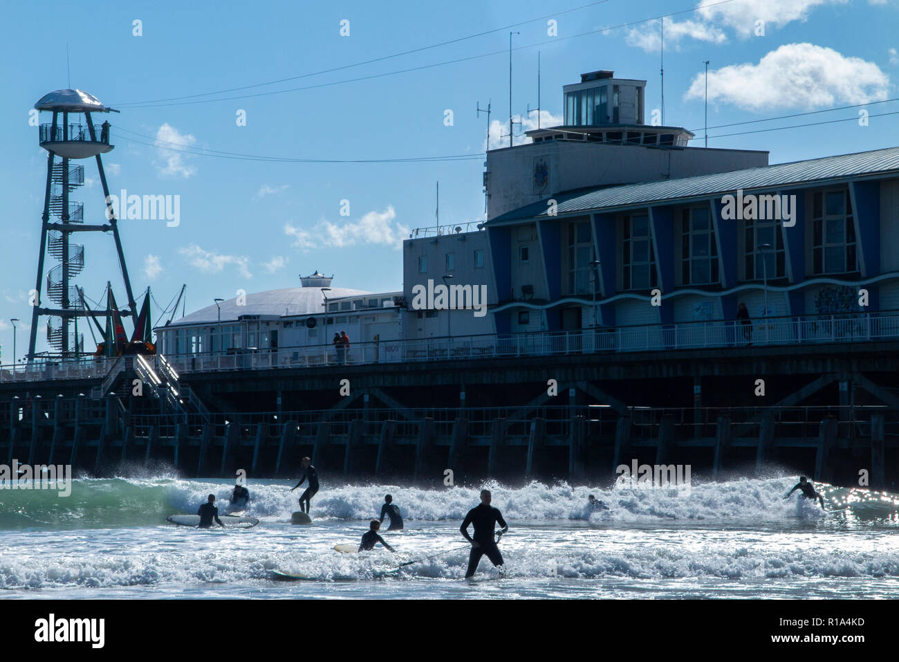 Surfers in the sea on Bournemouth beach in high summer, below the ...