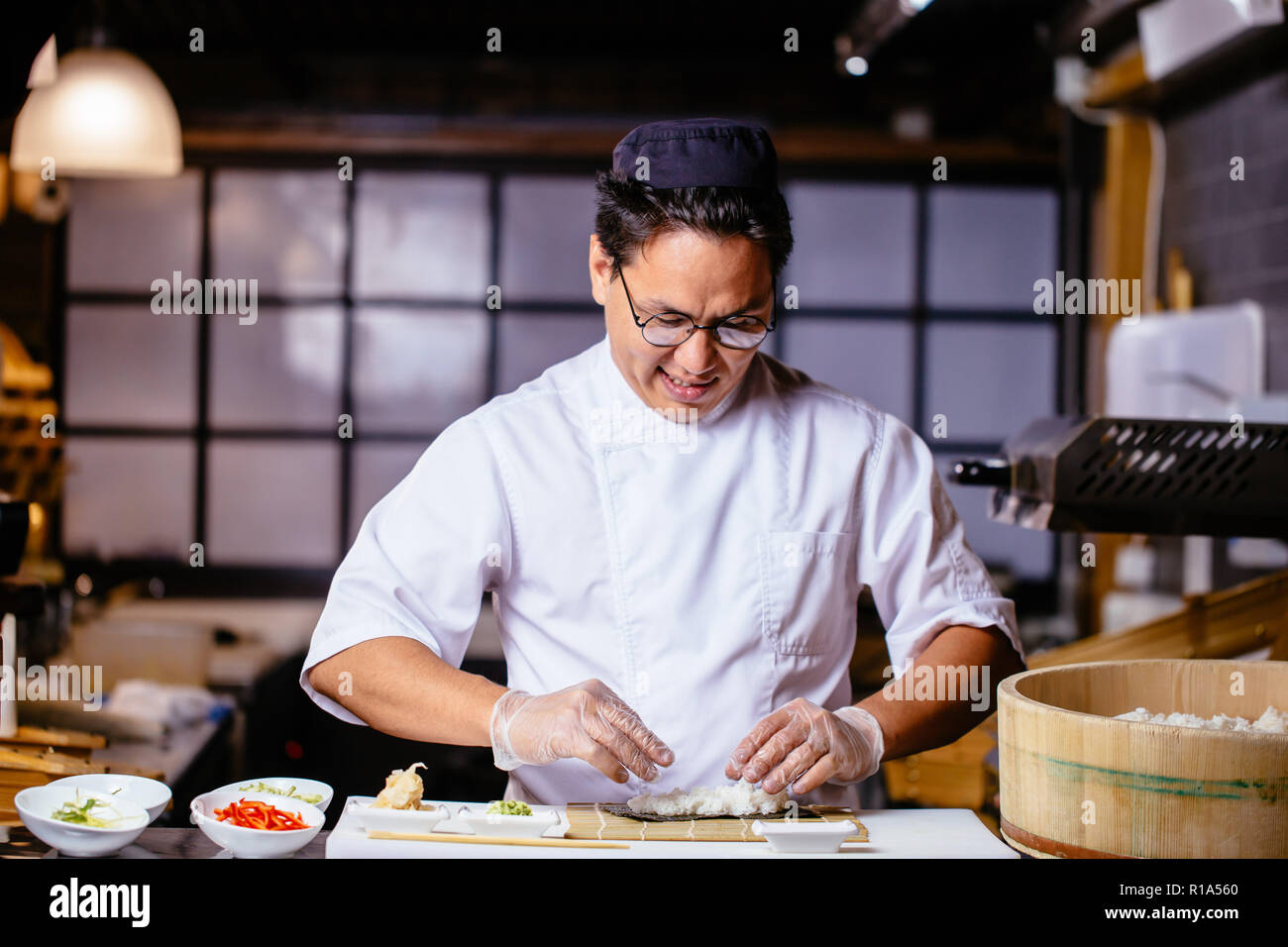 cheerful male chef is adding rice to meal Stock Photo - Alamy