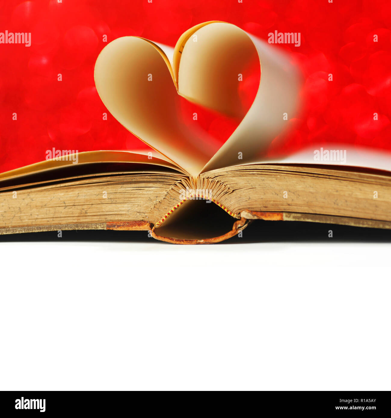 Heart shaped book pages on glitter background Stock Photo - Alamy
