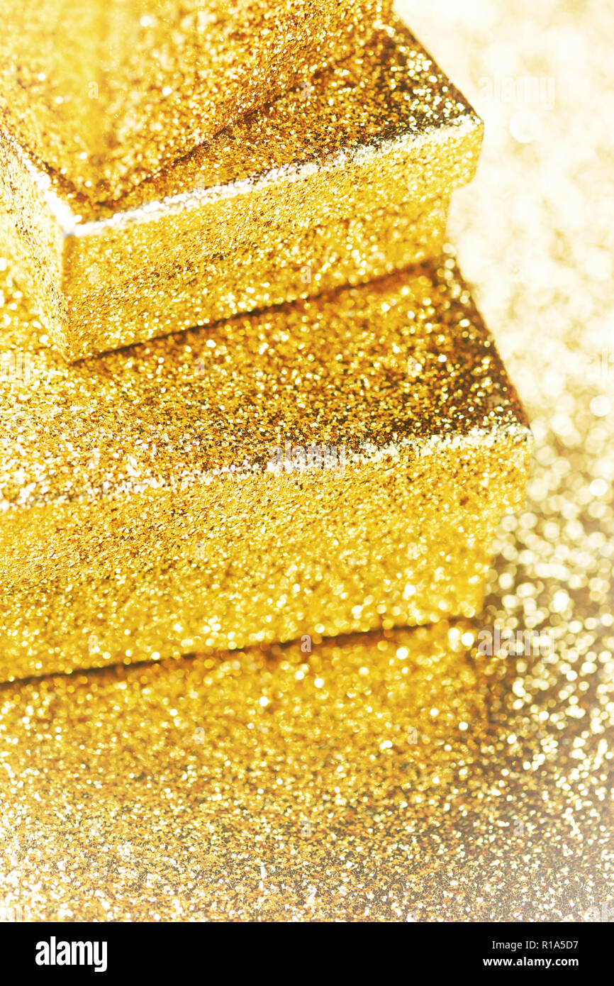 Decorative golden boxes with holiday gifts on shiny glitter background ...