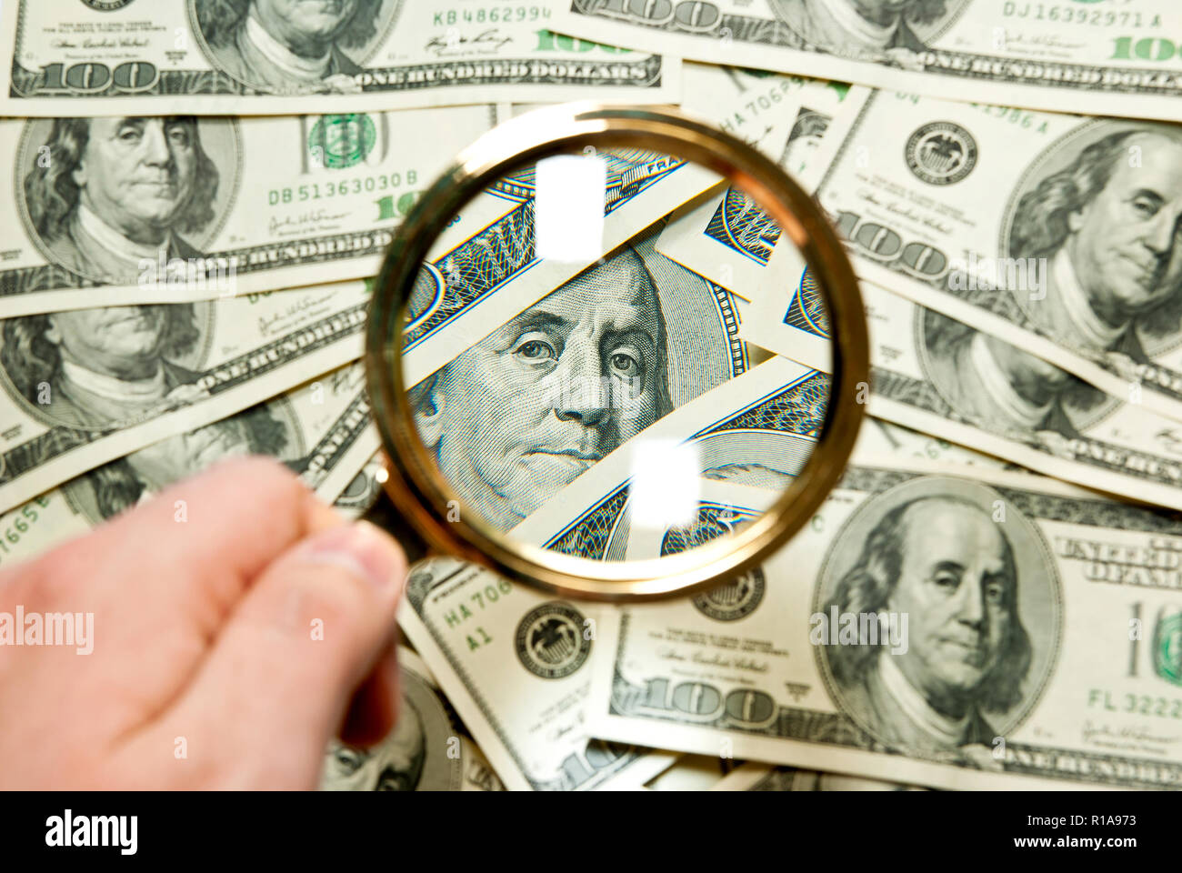 magnifying glass with background of dollars Stock Photo - Alamy