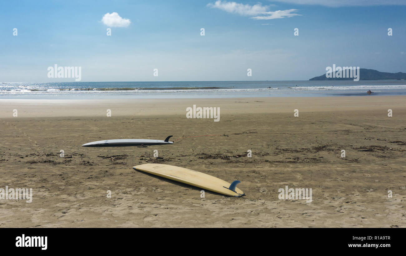 2 Surfboards on an empty sandy beach with small clouds Stock Photo - Alamy