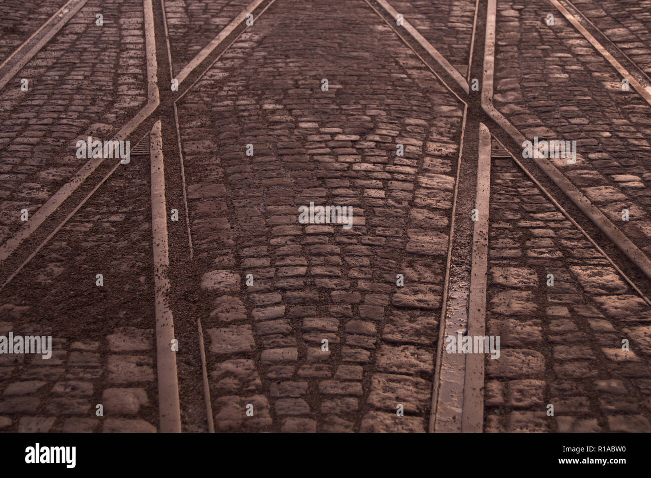 Crossing of tram rails on stone pavement background Stock Photo - Alamy