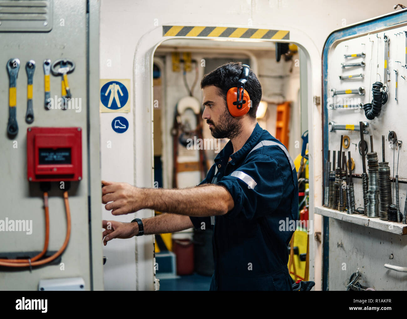 Marine engineer officer working in engine room Stock Photo - Alamy