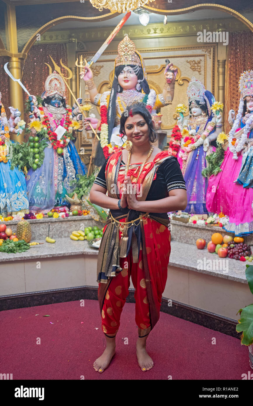 PANDITA. Portrait of a beautiful Hindu priest in front of statues of ...