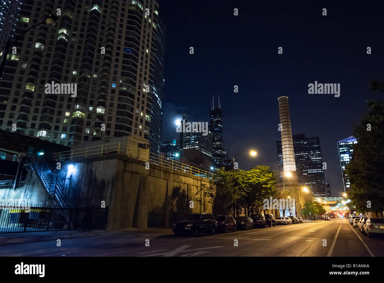 Chicago night street scene with a city tower, a smokestack, the skyline ...
