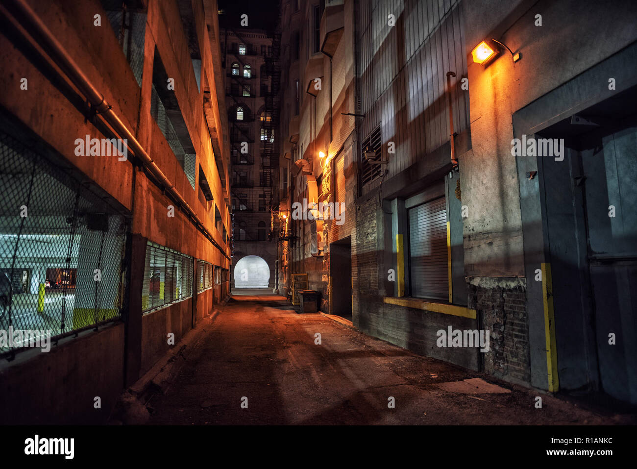 Dark and eerie downtown urban city alley with a loading dock next to a ...