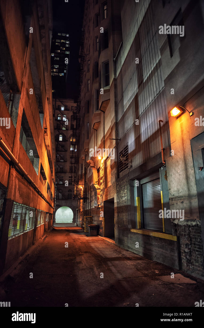 Dark and eerie downtown urban city alley with a loading dock next to a ...
