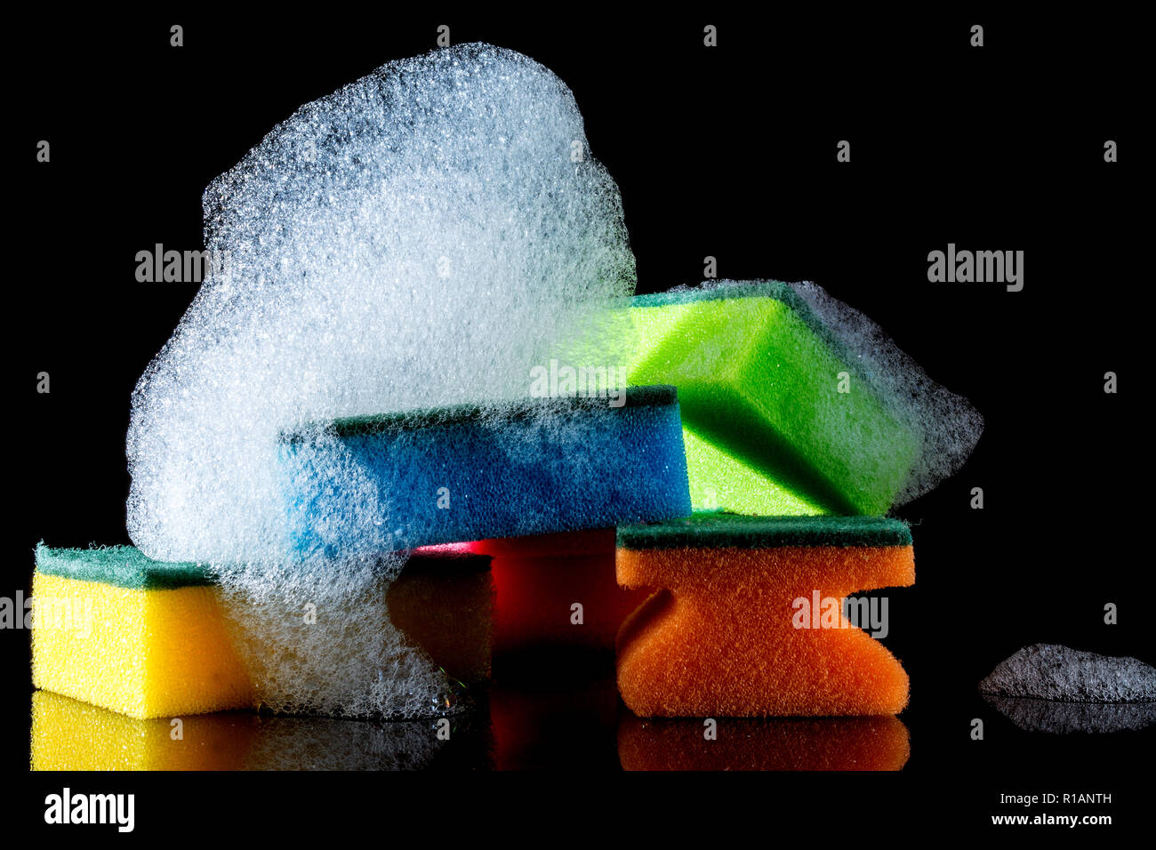 Colorful sponges with foam and reflection, bubbles, isolated on black ...