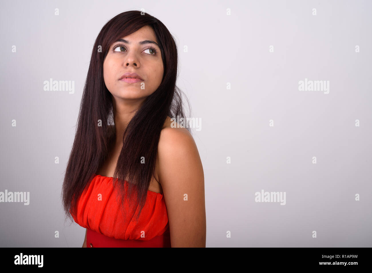 Close up of young Persian woman thinking while looking back and Stock ...