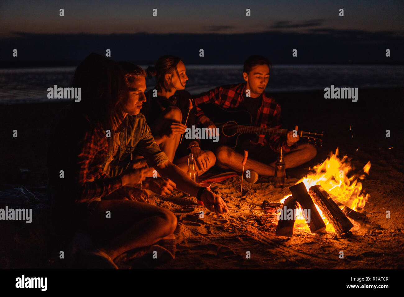 young friends have picnic with bonfire on the beach Stock Photo - Alamy