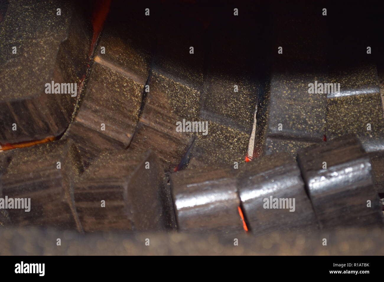 Close up of Brown Coal Briquettes on fire with red yellow flames inside ...