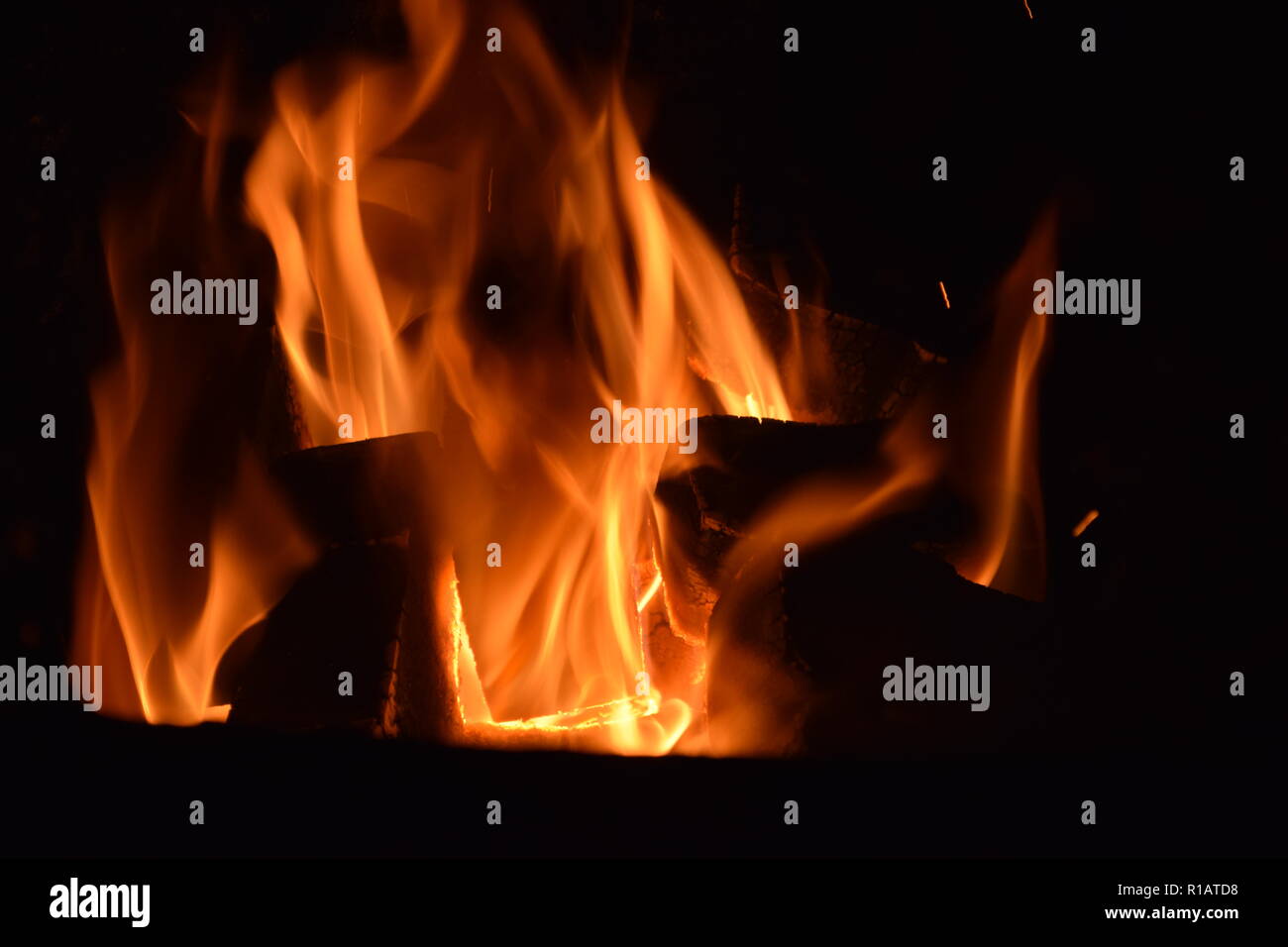 Close up of Brown Coal Briquettes on fire with red yellow flames inside ...