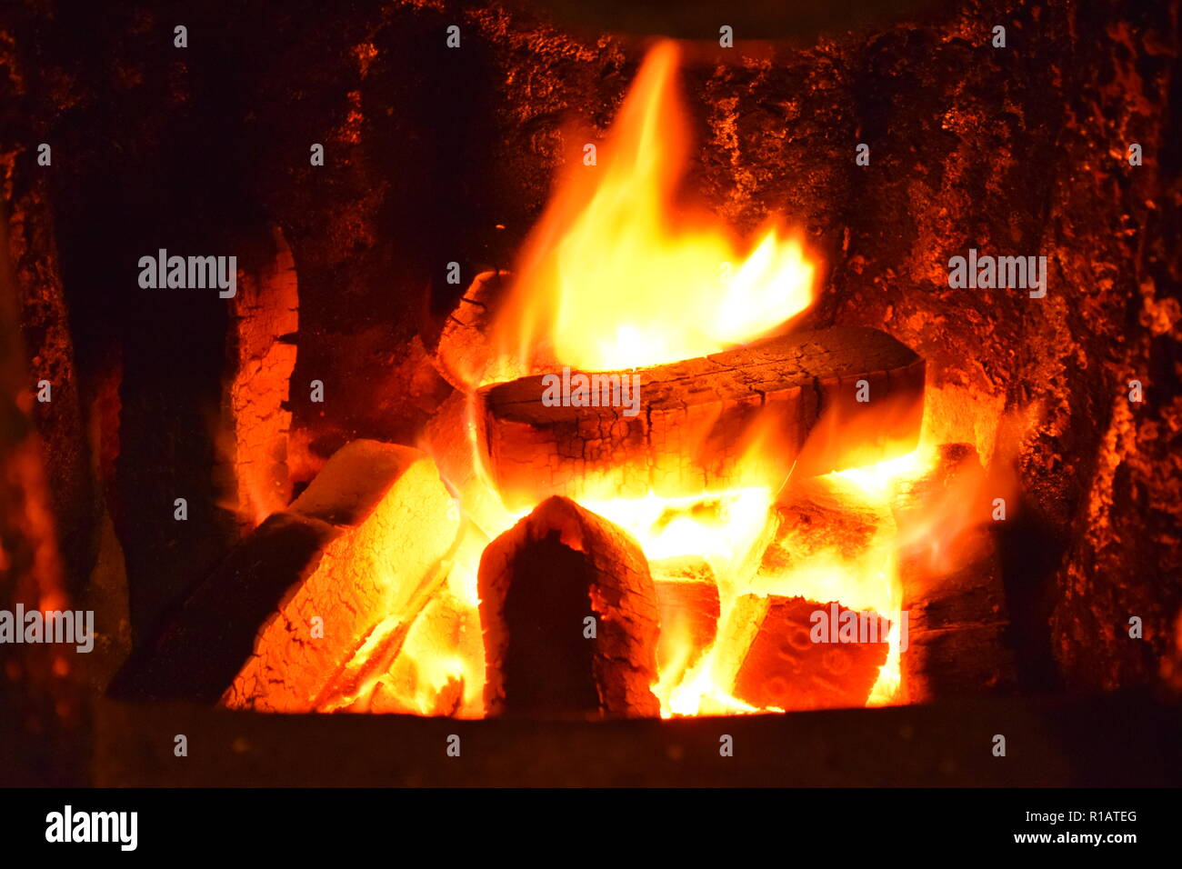 Close up of Brown Coal Briquettes on fire with red yellow flames inside ...