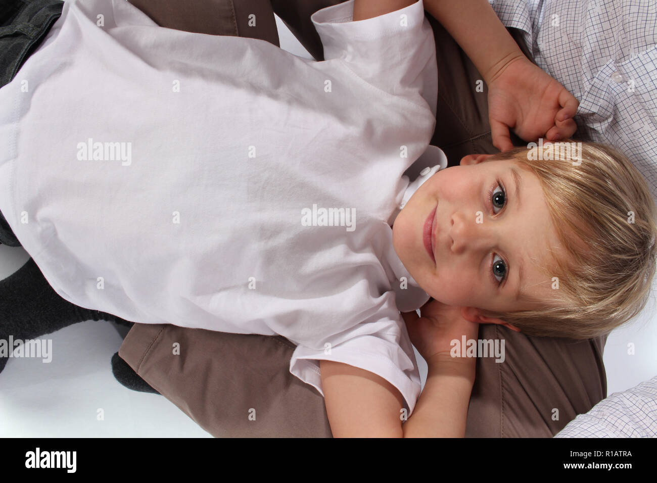 Adorable cute little boy lying in his daddy's lap Stock Photo - Alamy