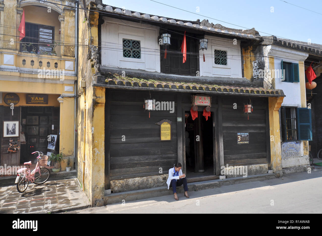 Hoi An, Vietnam - Apr. 13, 2011: Woman waits outside the old historic ...