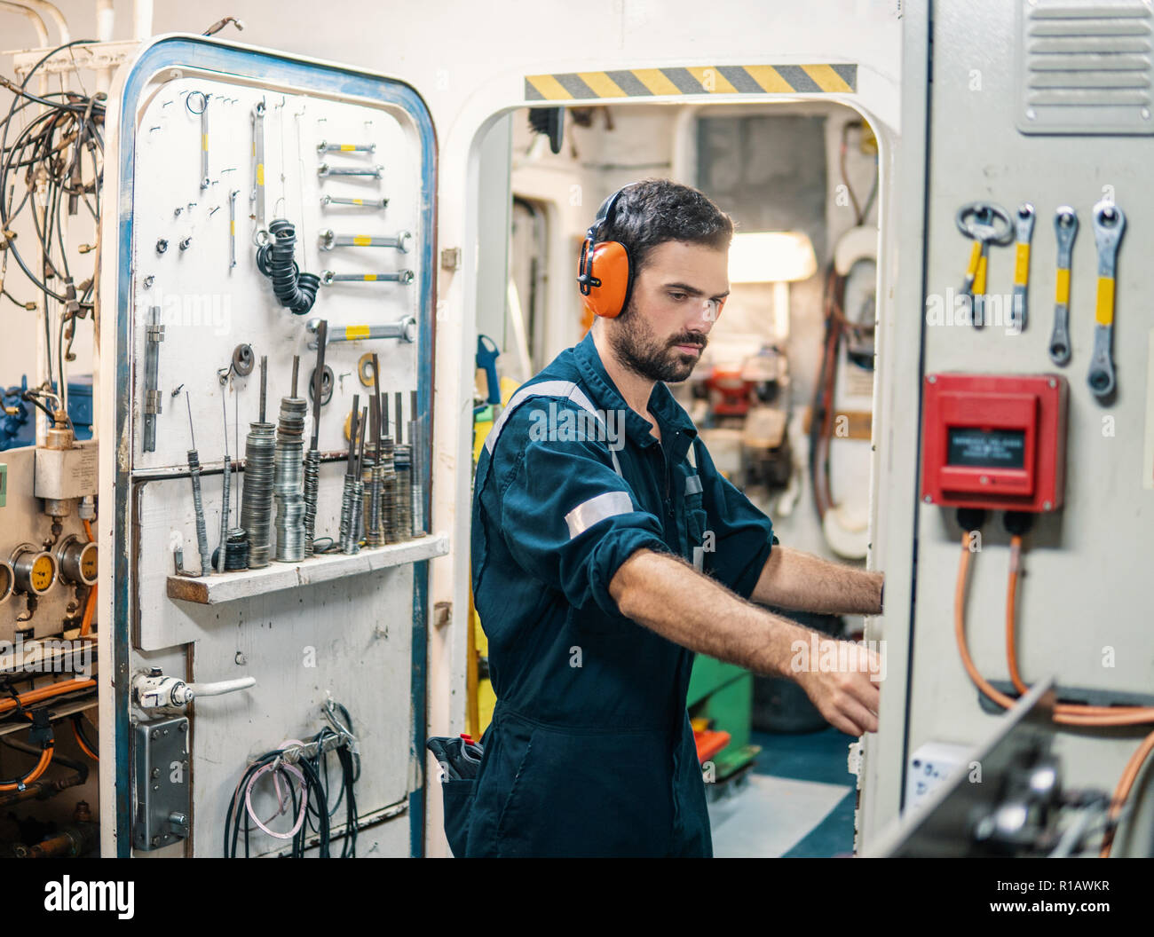 Marine engineer officer working in engine room Stock Photo - Alamy