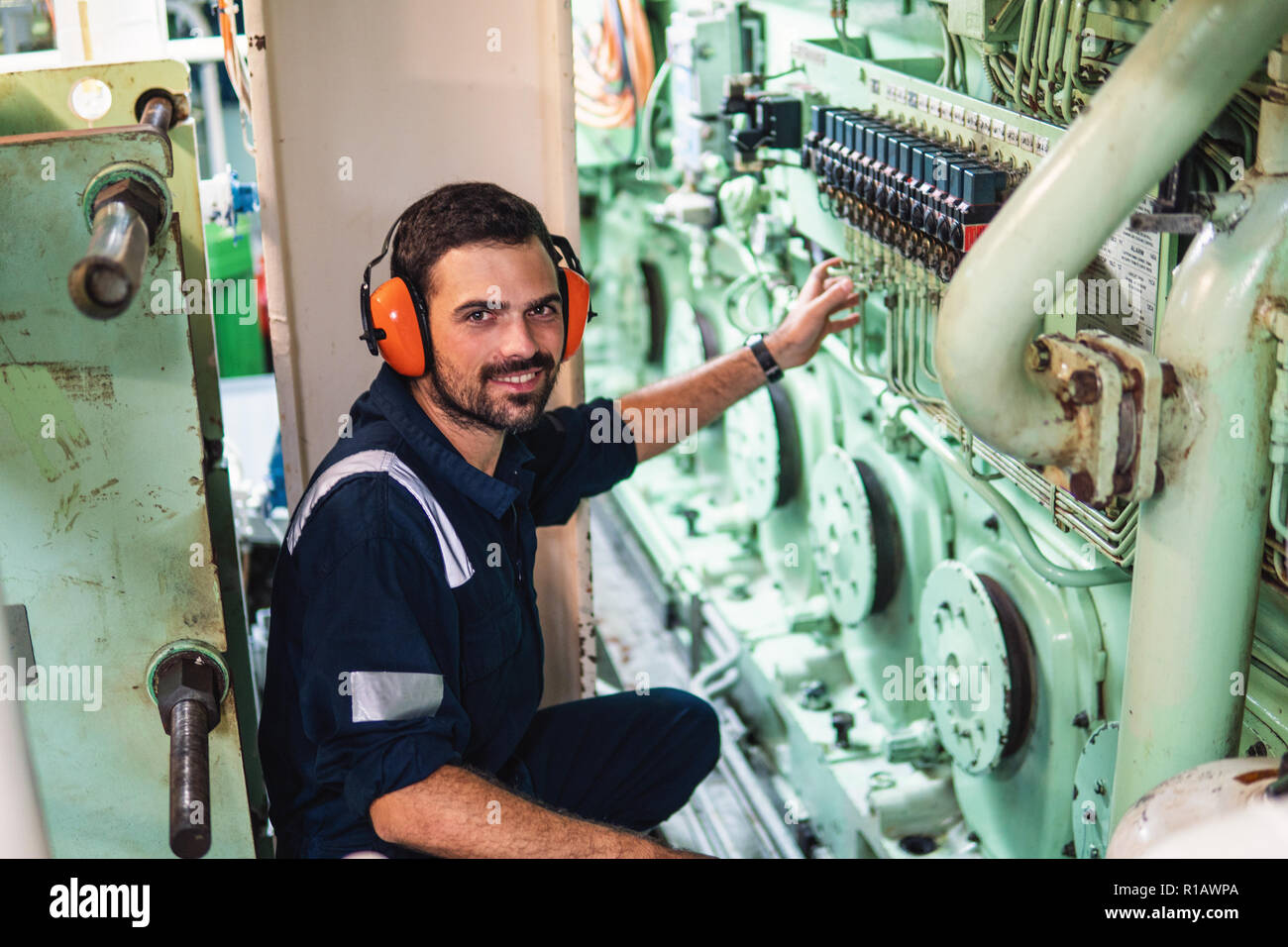 Marine engineer officer working in engine room Stock Photo - Alamy