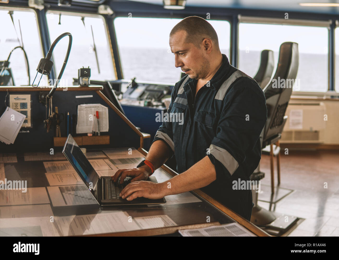 Marine navigational officer is using laptop or notebook at sea Stock ...