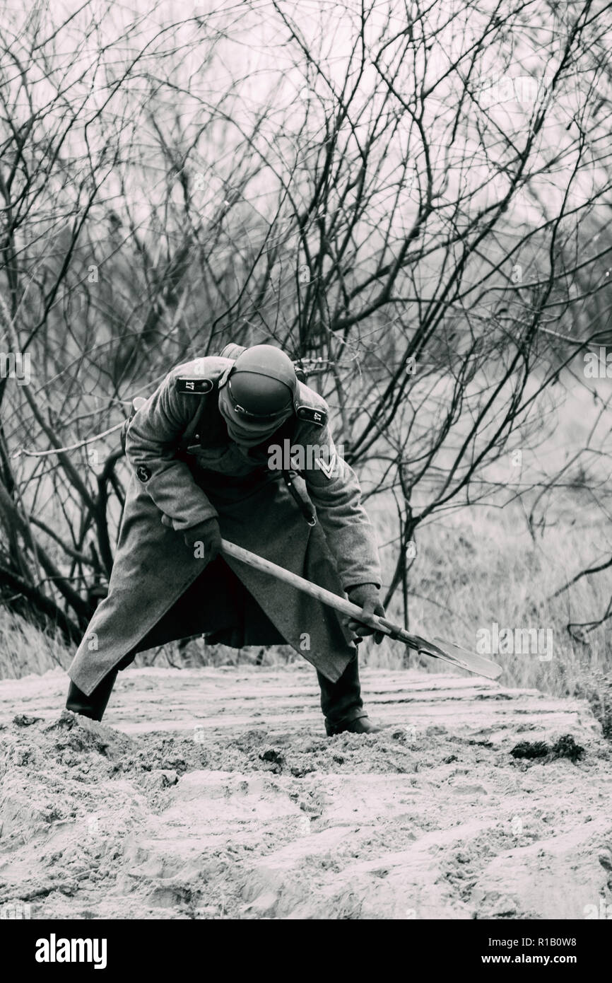 Wehrmacht army soldier in a uniform with a shovel digging a trench ...