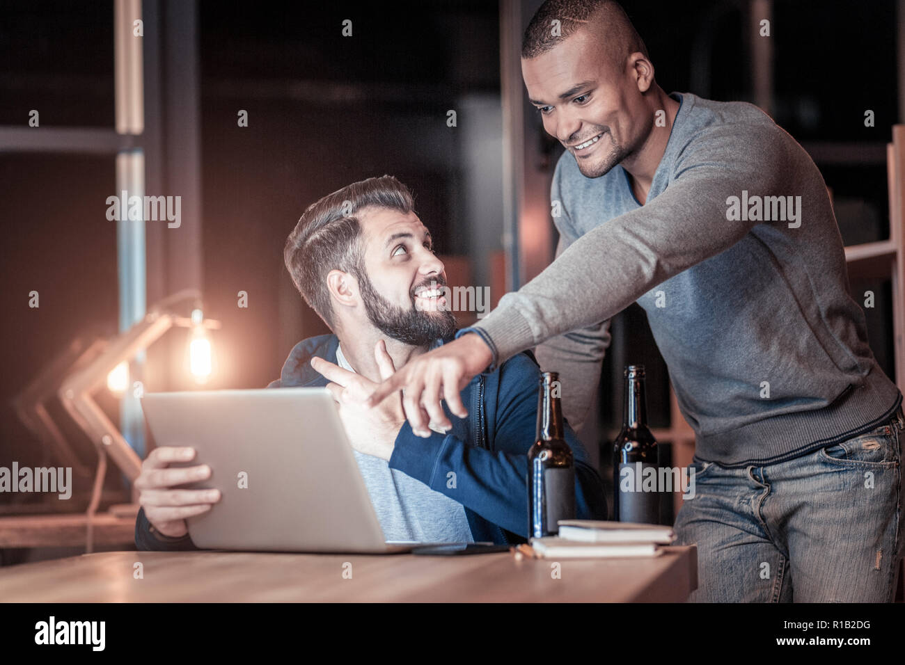 Attractive international worker pointing at computer Stock Photo - Alamy