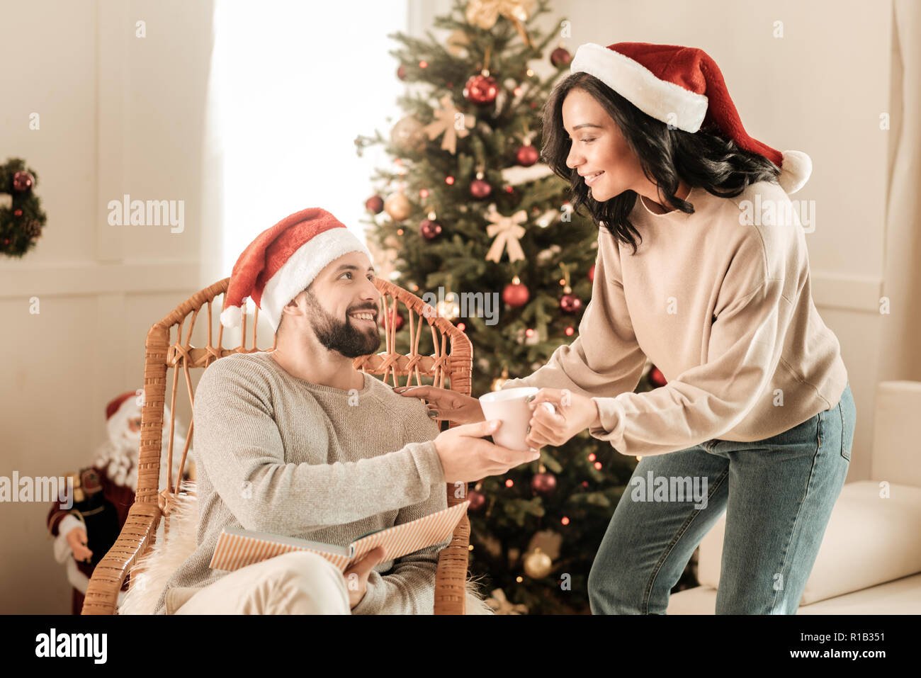 Pleasant young woman giving tea to her boyfriend Stock Photo - Alamy